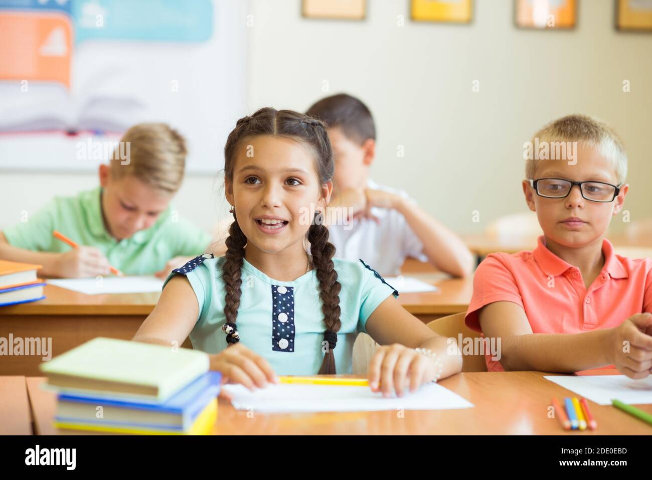 Happy schoolchildren studing and answer questions in classroom during a ...