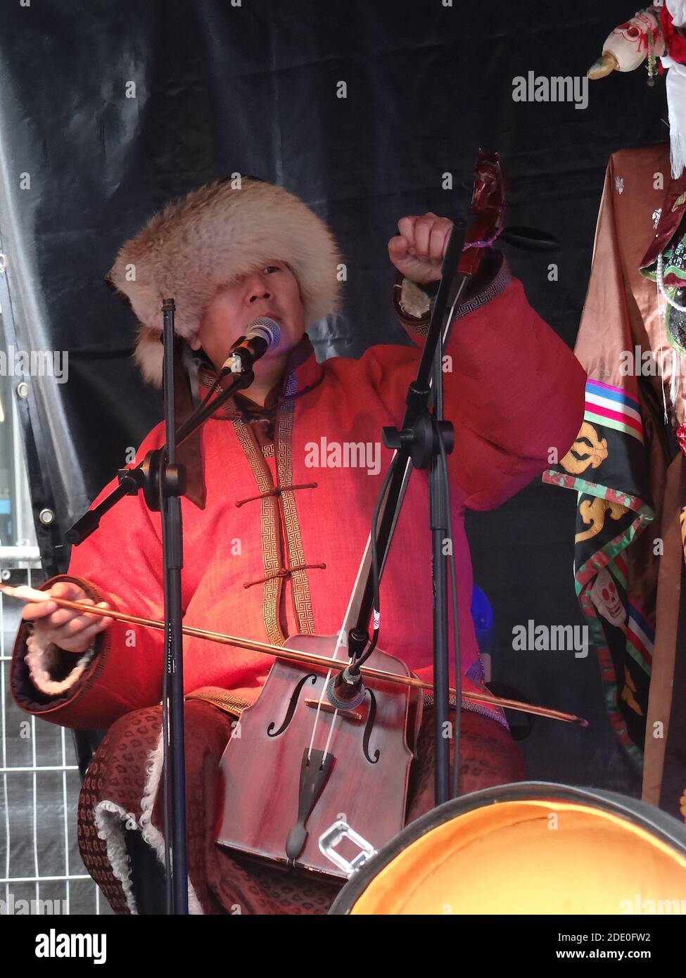 Mongolian musician in national costume performs on stage outdoors at a ...