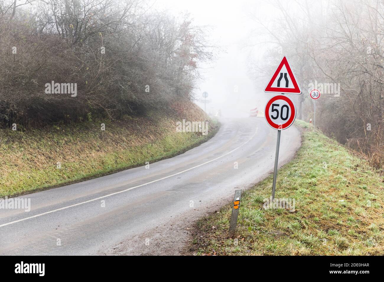 Fog on a country road. Speed traffic sign. Dangerous place. Slippery ...