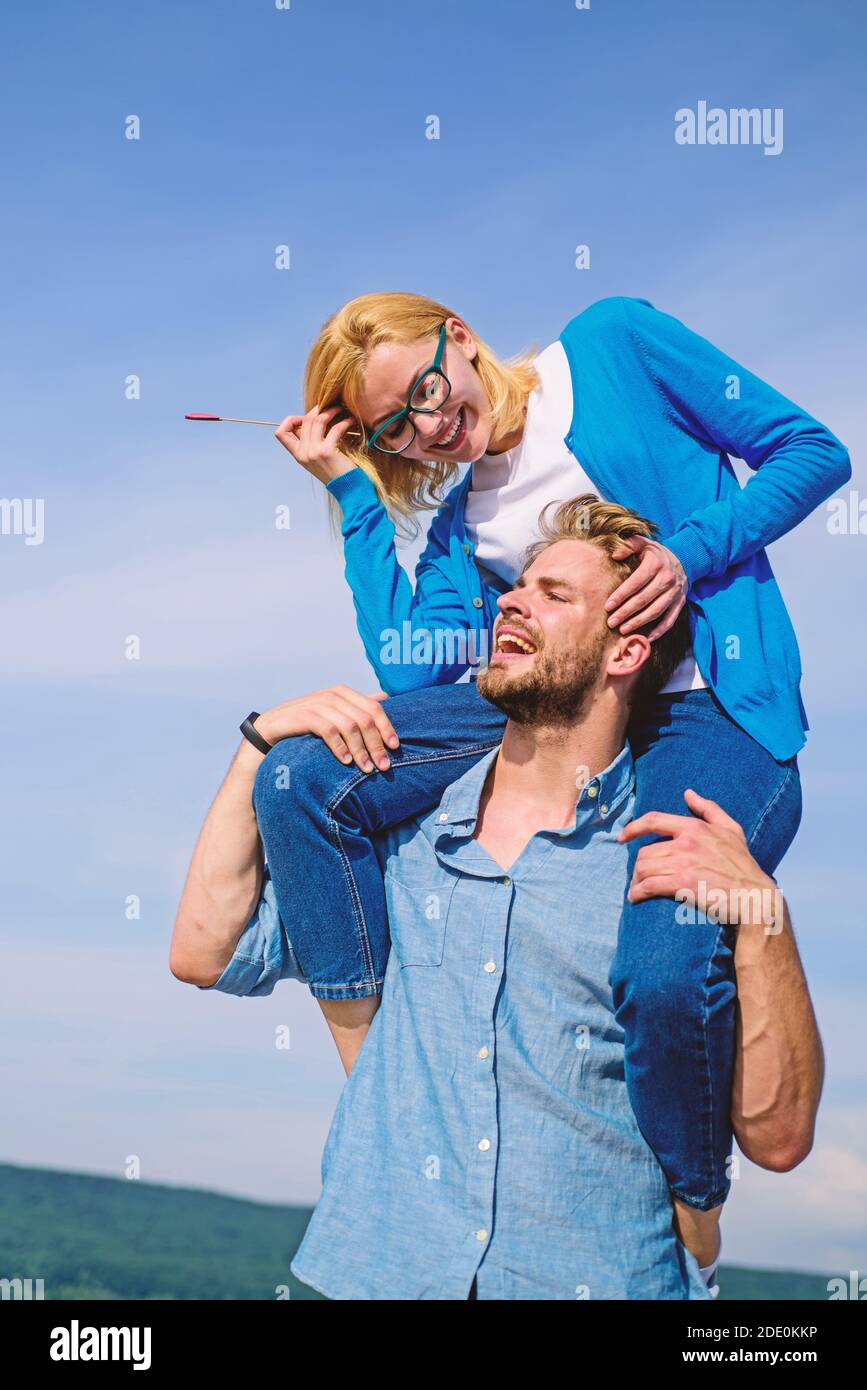 Man carries girlfriend on shoulders, sky background. Woman enjoy ...