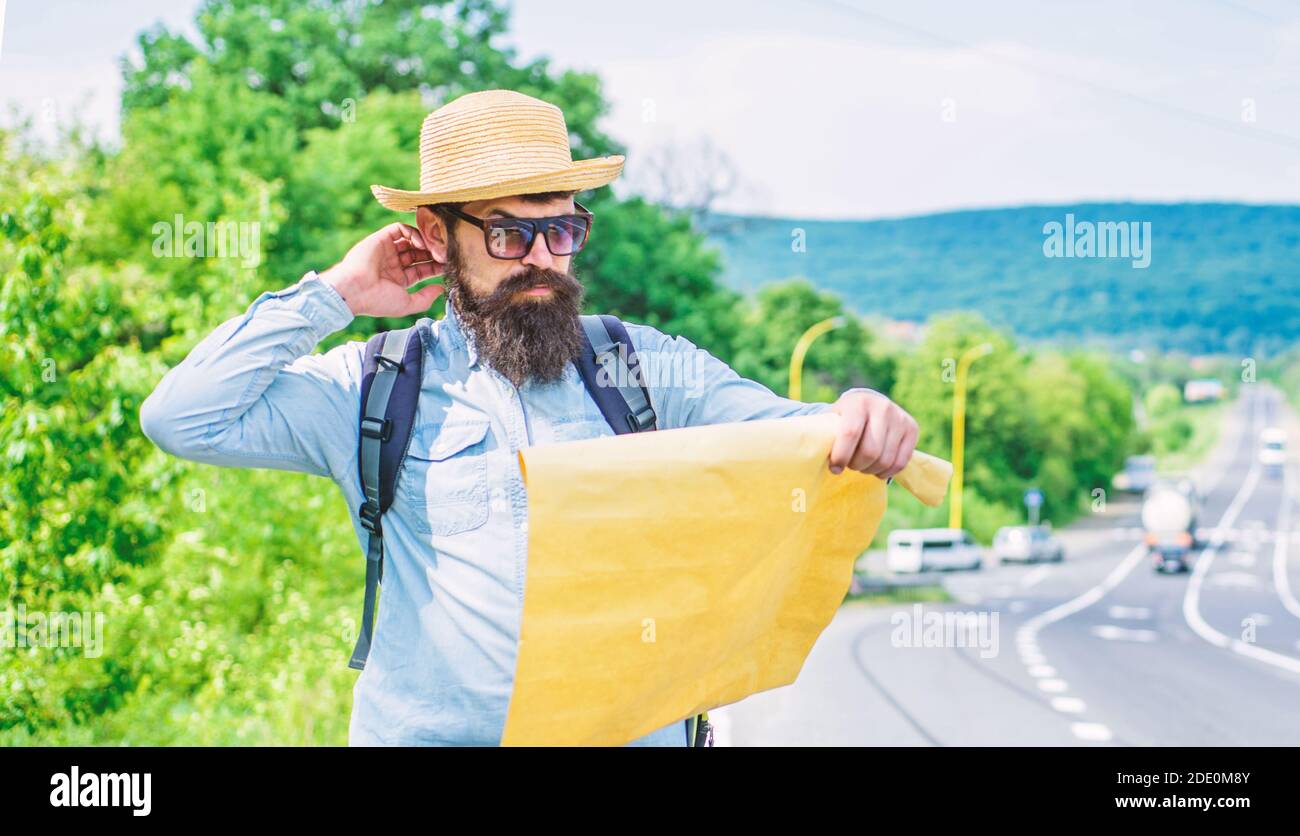 Pick up local map. Tourist backpacker looks at map choosing travel ...