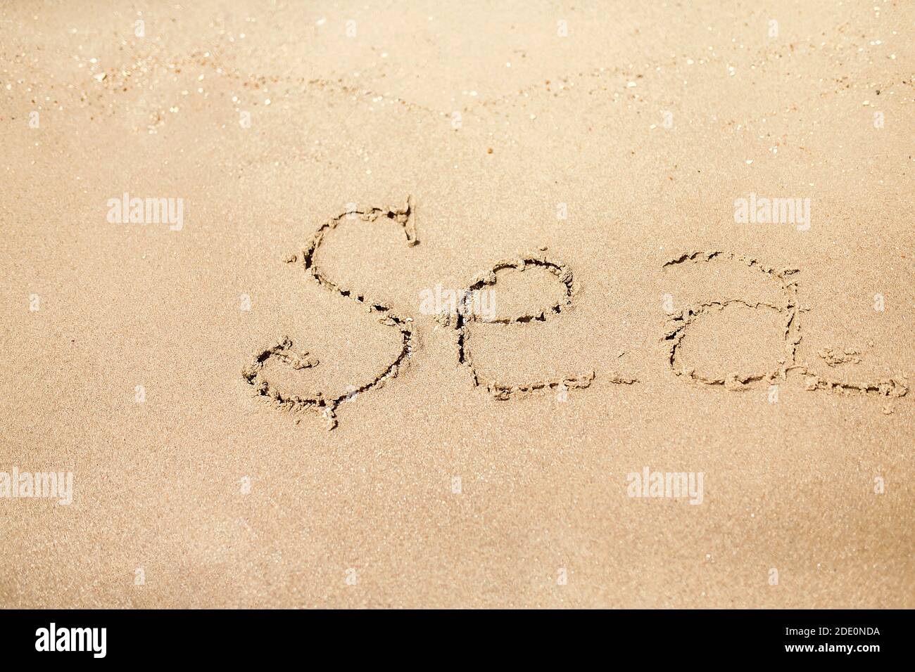 Handwritten Sea Word on the Sand Coast. Wonderful words on beach sand ...