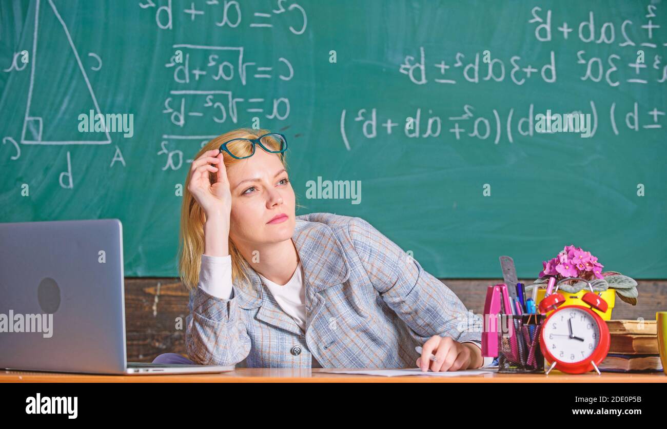 Teacher woman sit table classroom chalkboard background. Teacher busy ...