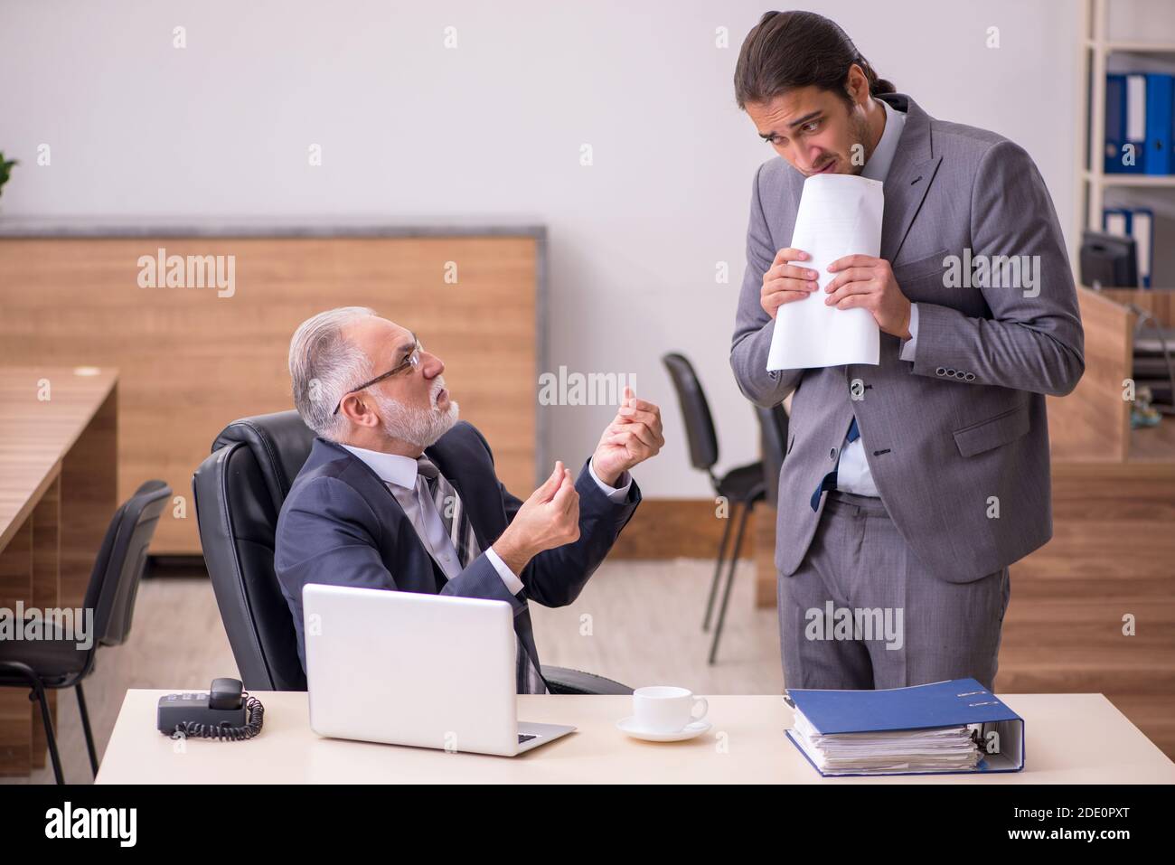 Old male boss and young male assistant in the office Stock Photo - Alamy