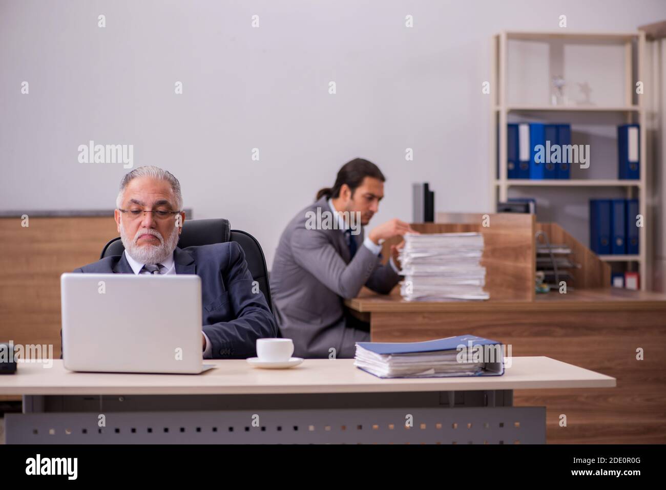Old male boss and young male assistant in the office Stock Photo - Alamy