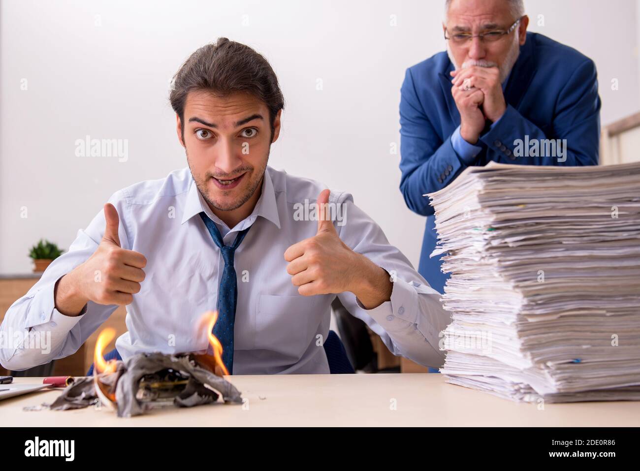 Male employee and his old boss burning papers at workplace Stock Photo ...