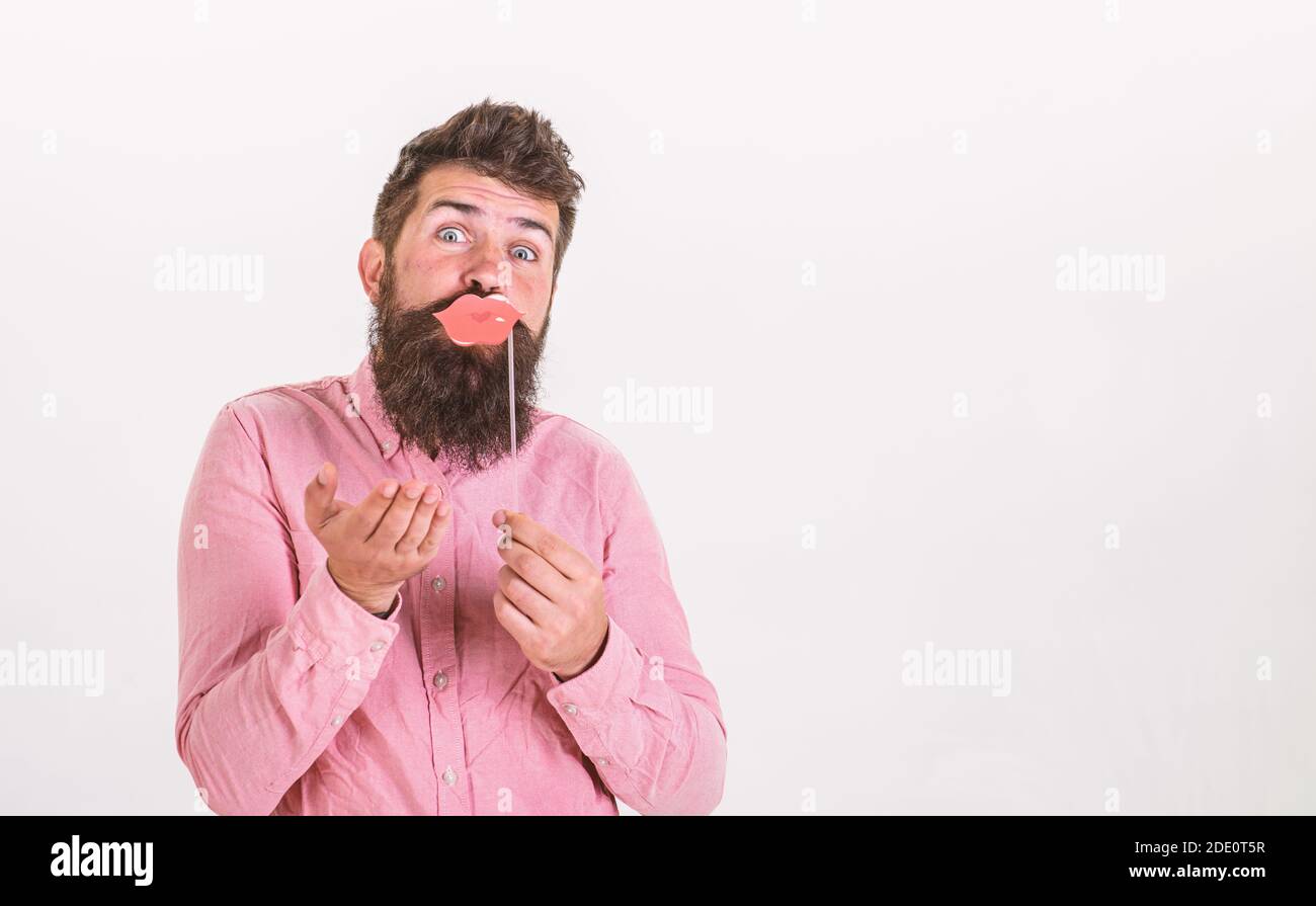 Photo booth fun concept. Man holding party props lips, white background ...