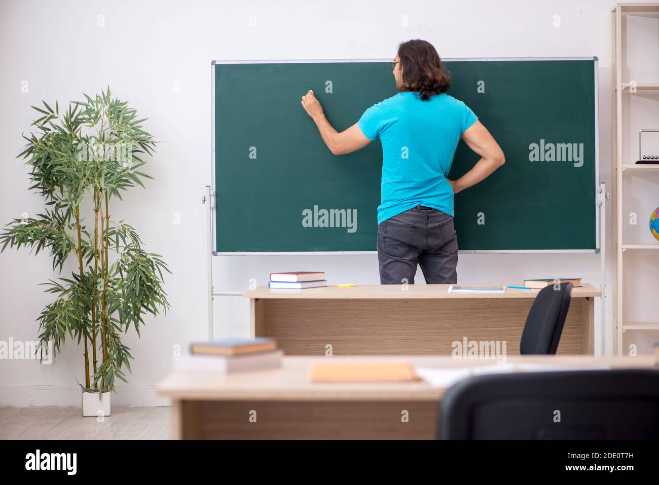 Young student in front of green board Stock Photo - Alamy