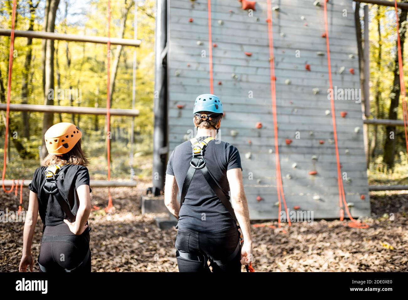 Well-equipped man and woman walking to the climbing wall outdoors ...