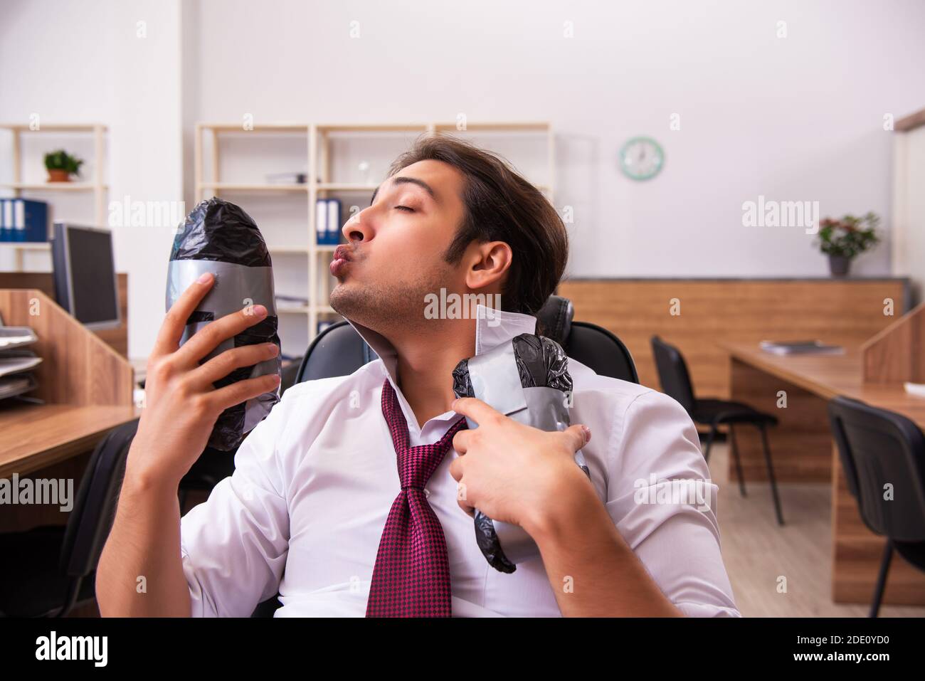 Young drug addicted male employee sitting at workplace Stock Photo - Alamy
