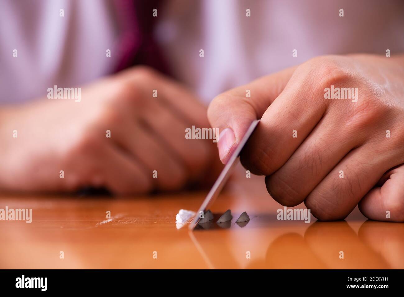 Young drug addicted male employee sitting at workplace Stock Photo - Alamy