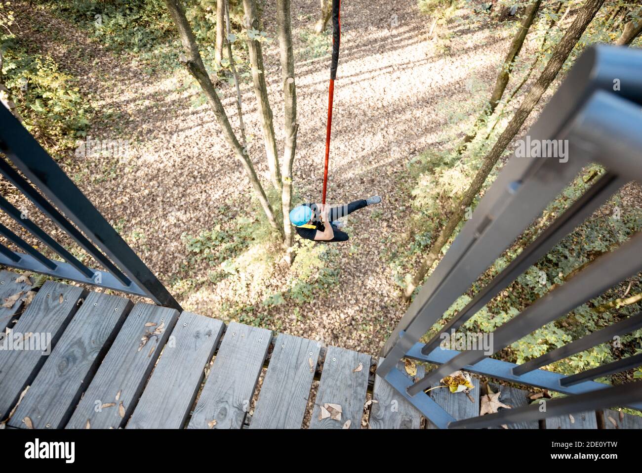 Man jumping from a bungee tower, having an active recreation in a rope ...