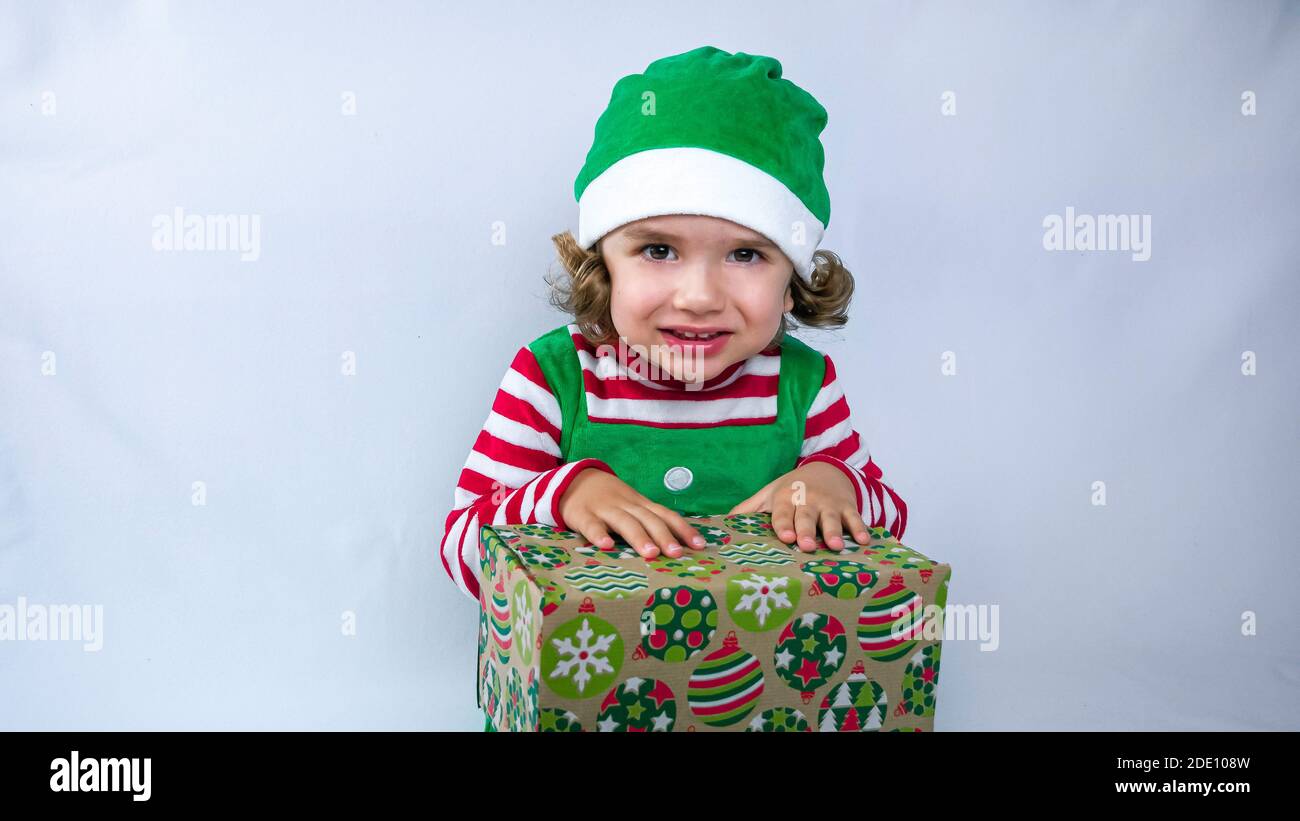 Little elf with a cute smile is sitting on the white background and ...