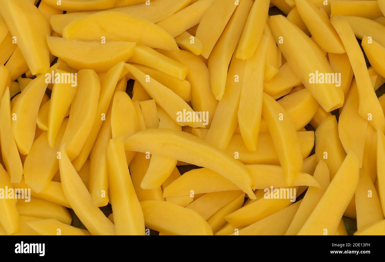 Sliced potatoes raw texture background. In the process of cooking ...