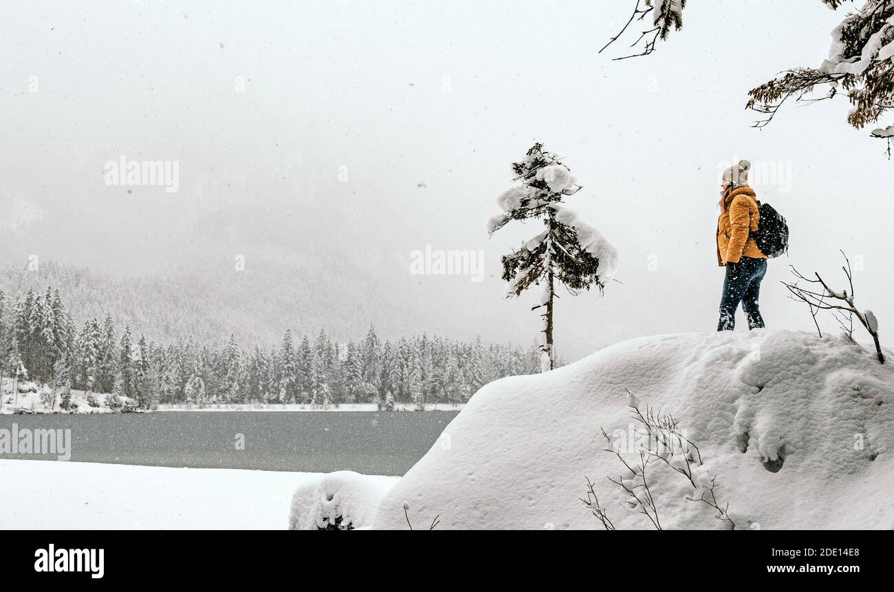A view of a young female hiker with a backpack enjoying the view of a ...