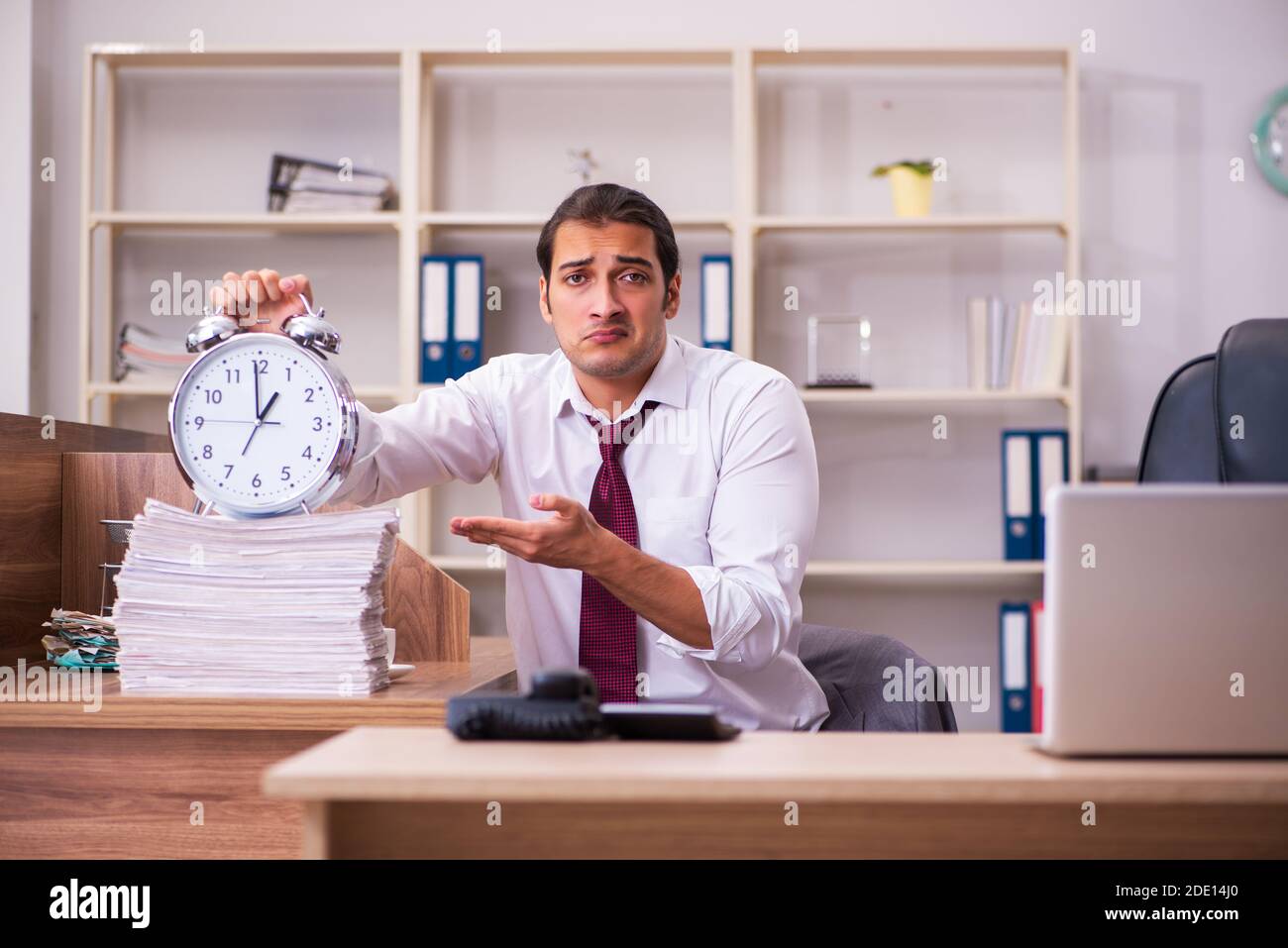 Tired employee in time management concept Stock Photo - Alamy
