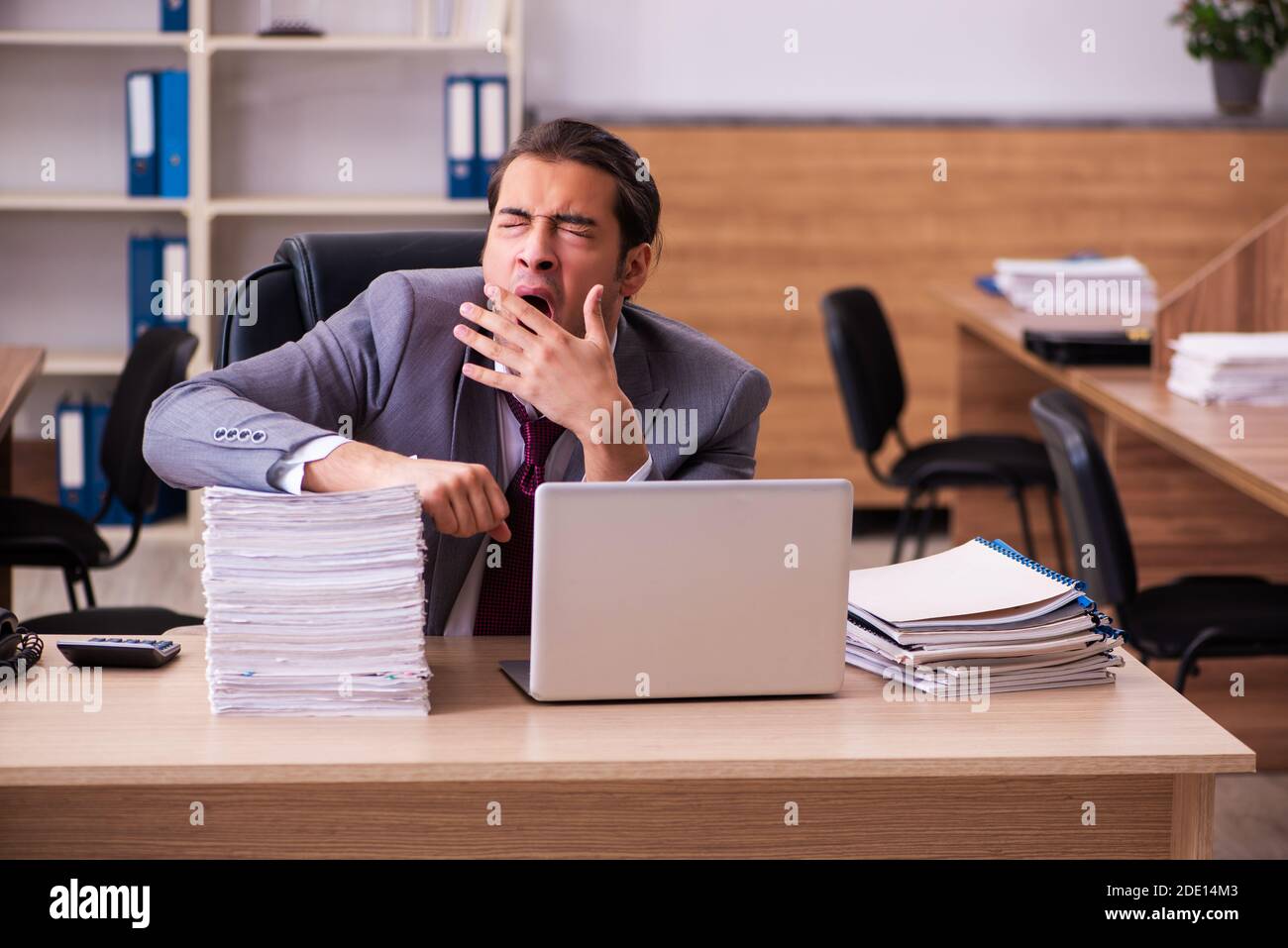 Young employee extremely tired with excessive work Stock Photo - Alamy