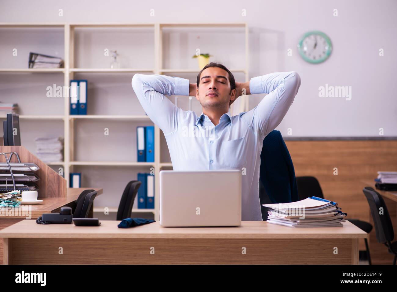 Young employee doing physical exercises at workplace Stock Photo - Alamy