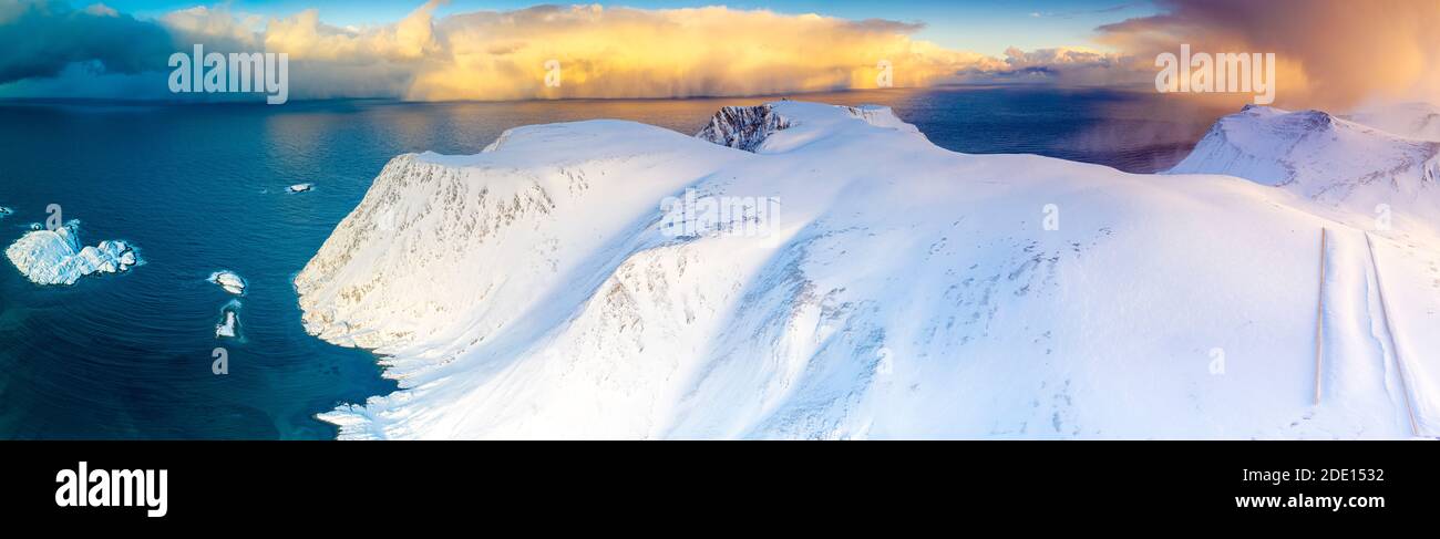 Aerial view of sunrise on snow capped mountains and blue arctic sea ...