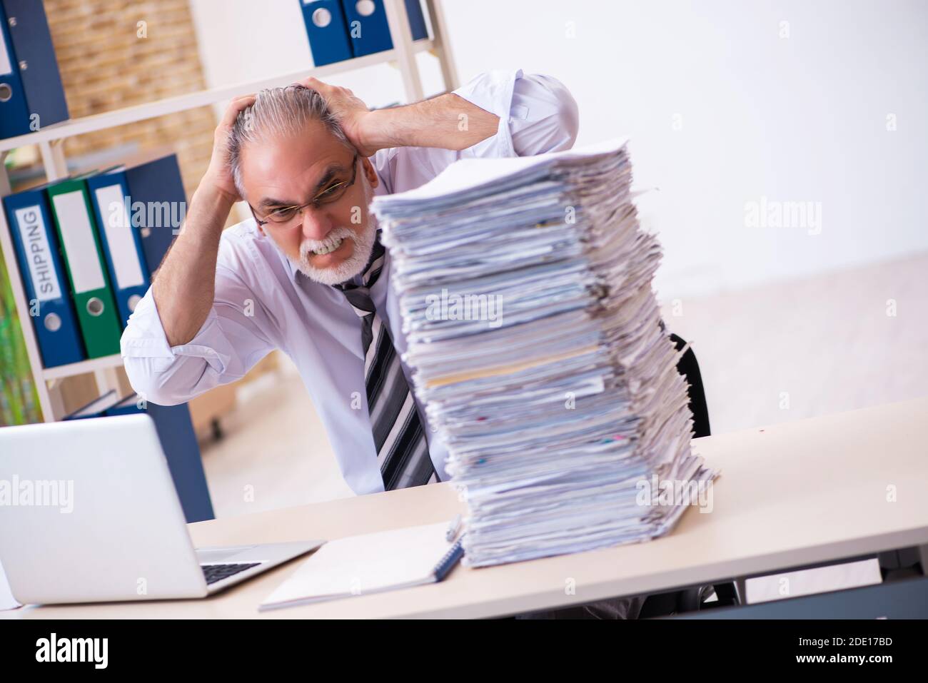 Old employee unhappy with excessive work in the office Stock Photo - Alamy