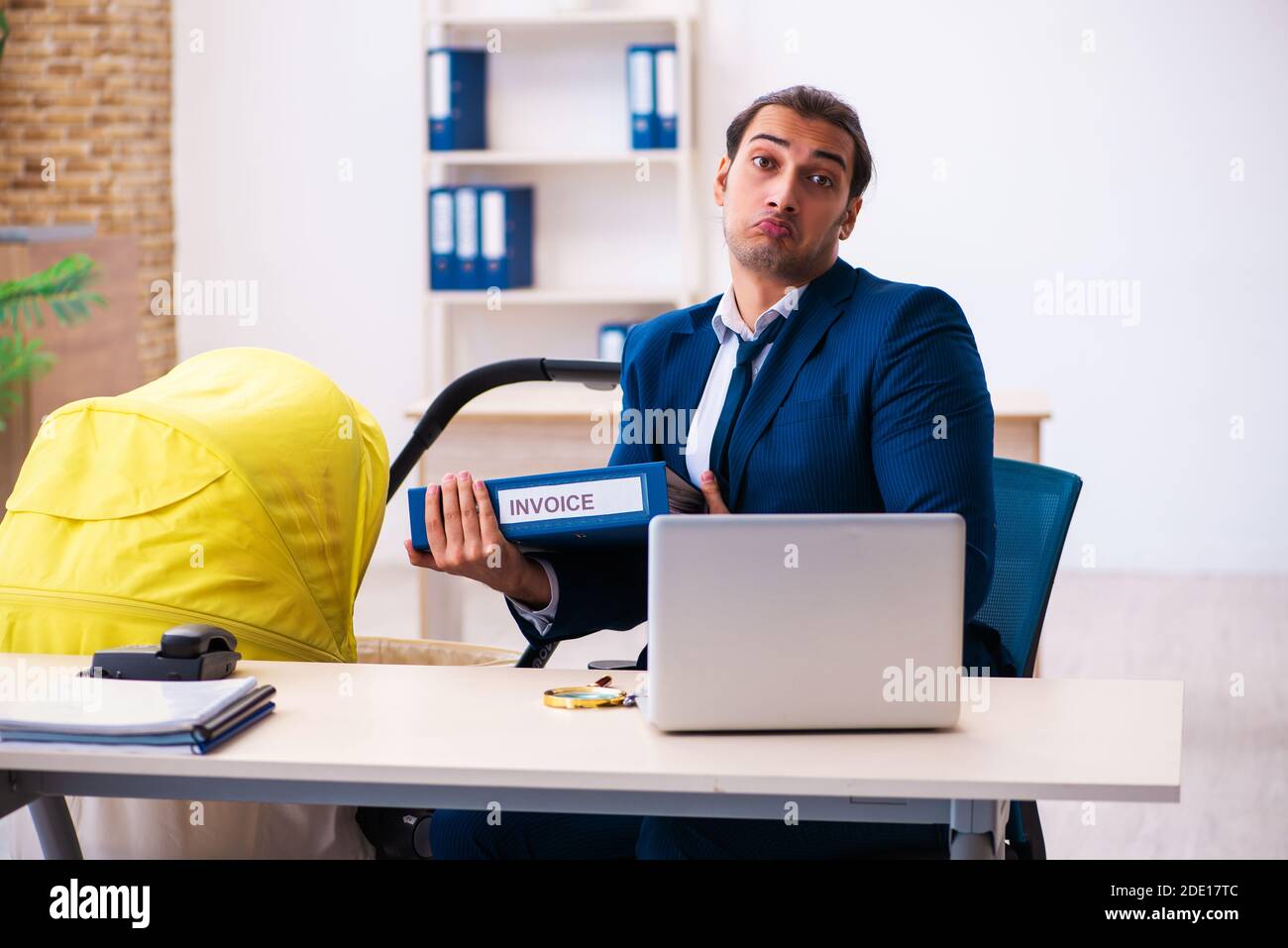Young employee looking after kid at workplace Stock Photo - Alamy