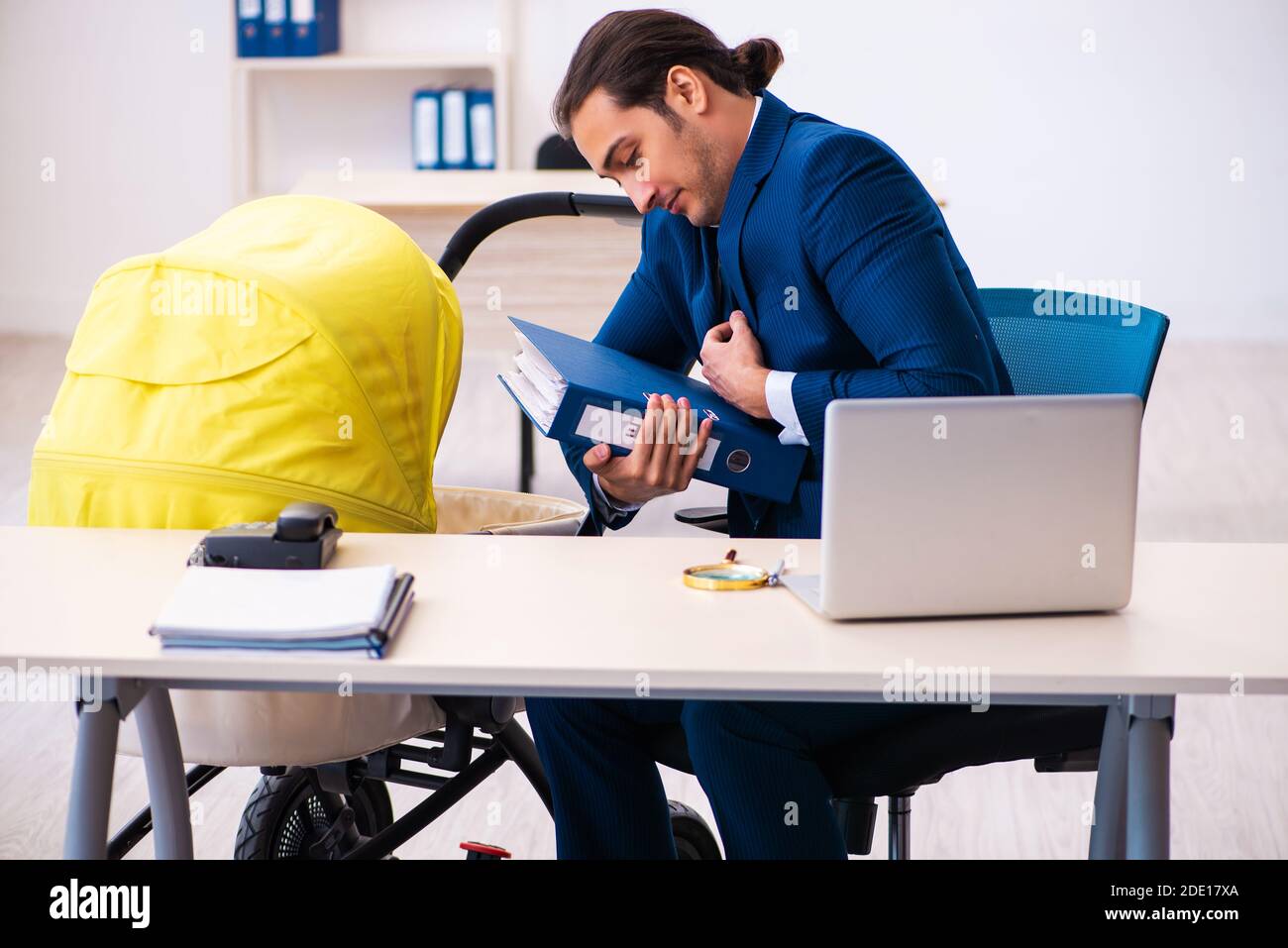 Young employee looking after kid at workplace Stock Photo - Alamy