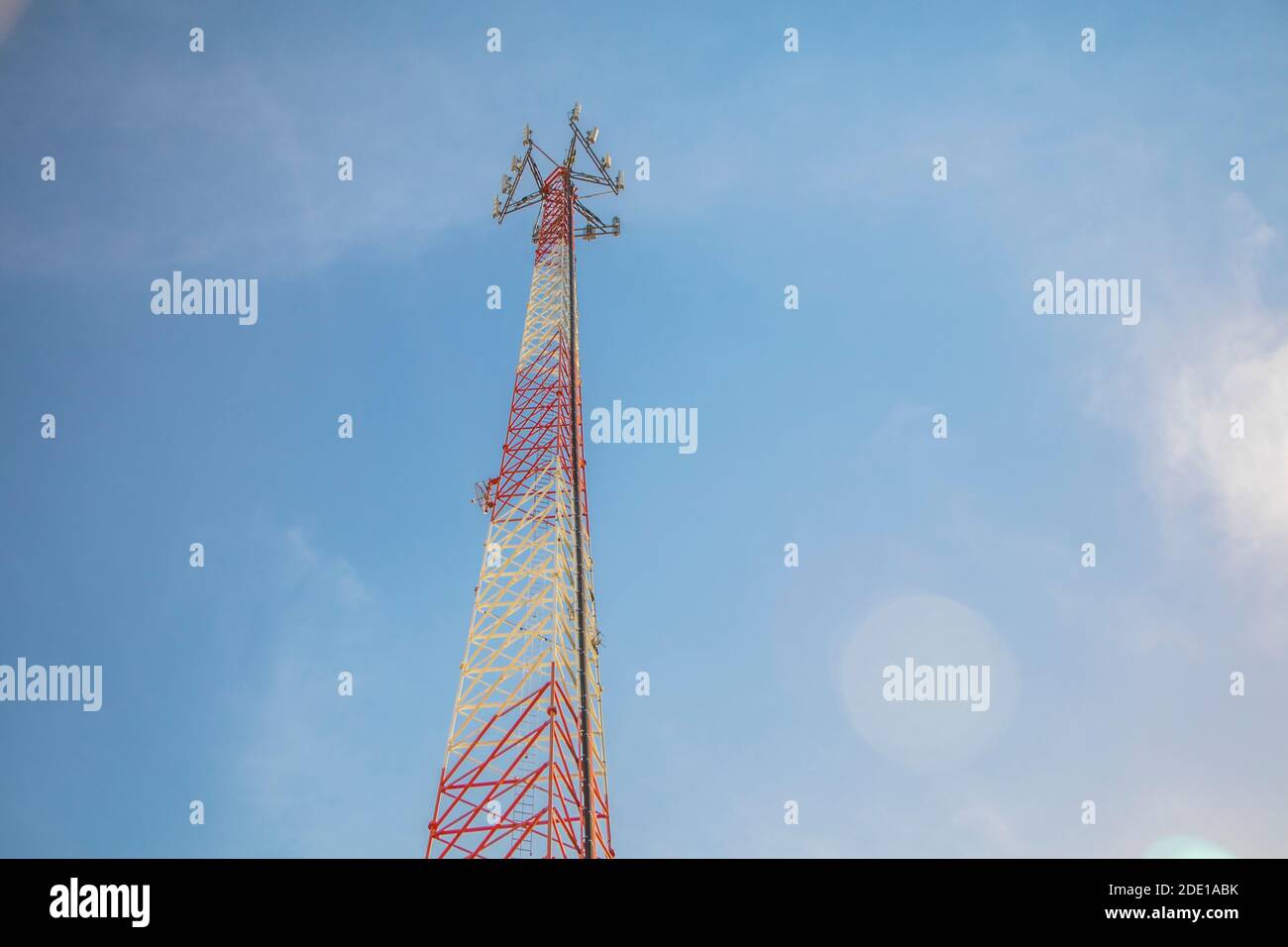 A red and white cell phone tower looking up and clear blue skies Stock Photo - Alamy