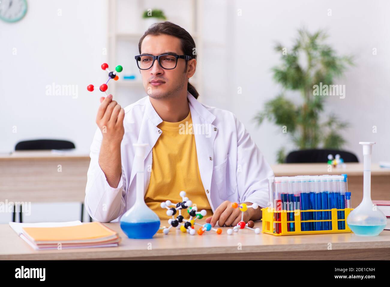 Young chemist studying molecular model in the classroom Stock Photo - Alamy