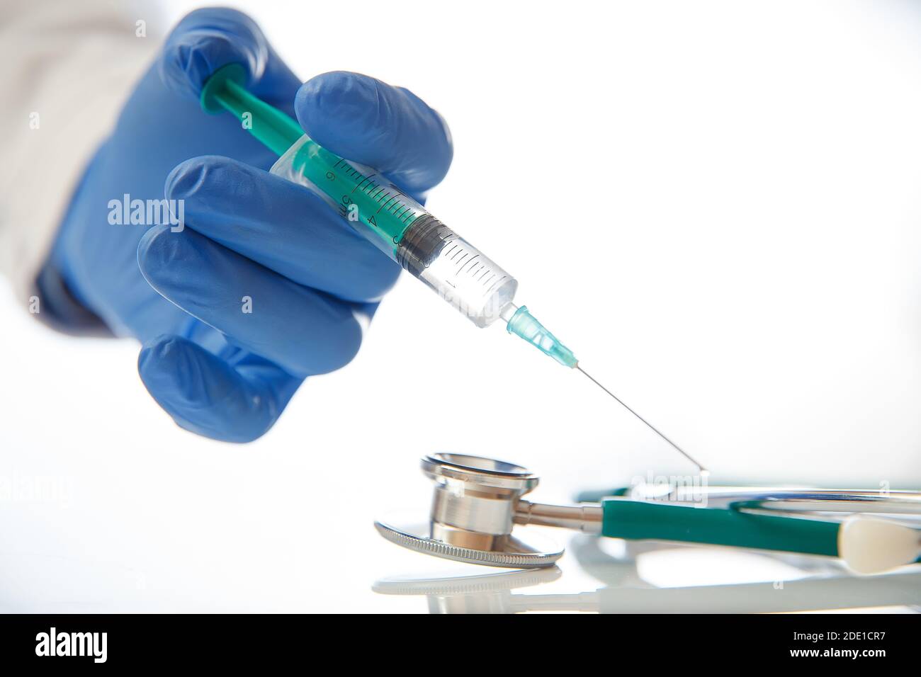 Doctor holding a medical injection syringe and stethoscope Stock Photo ...
