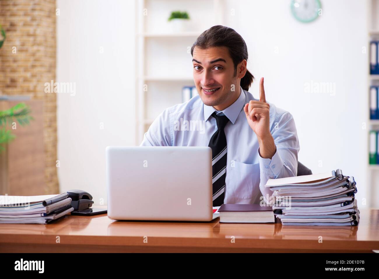 Young employee working at workplace Stock Photo - Alamy