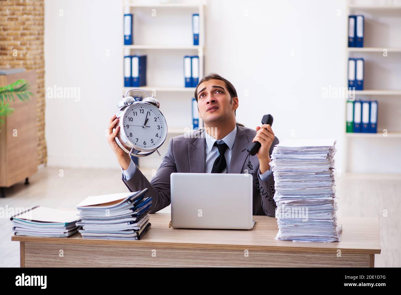 Workload employee in time management concept Stock Photo - Alamy