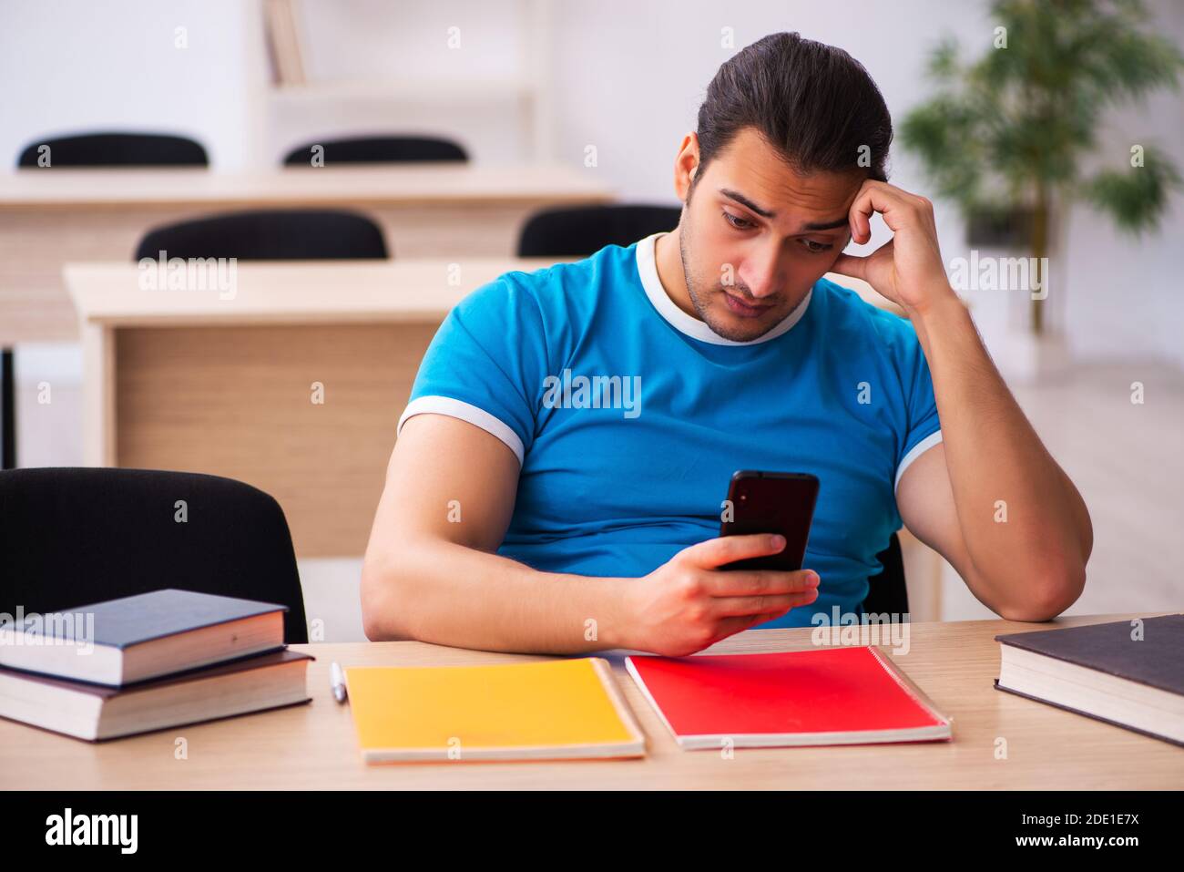 Exhausted student preparing for the exams in the classroom Stock Photo ...