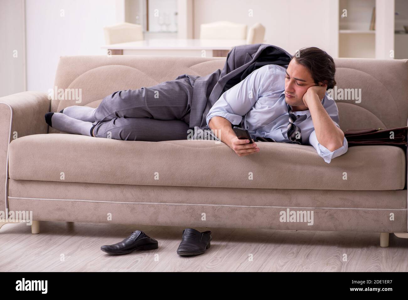Tired businessman coming home after working day Stock Photo - Alamy