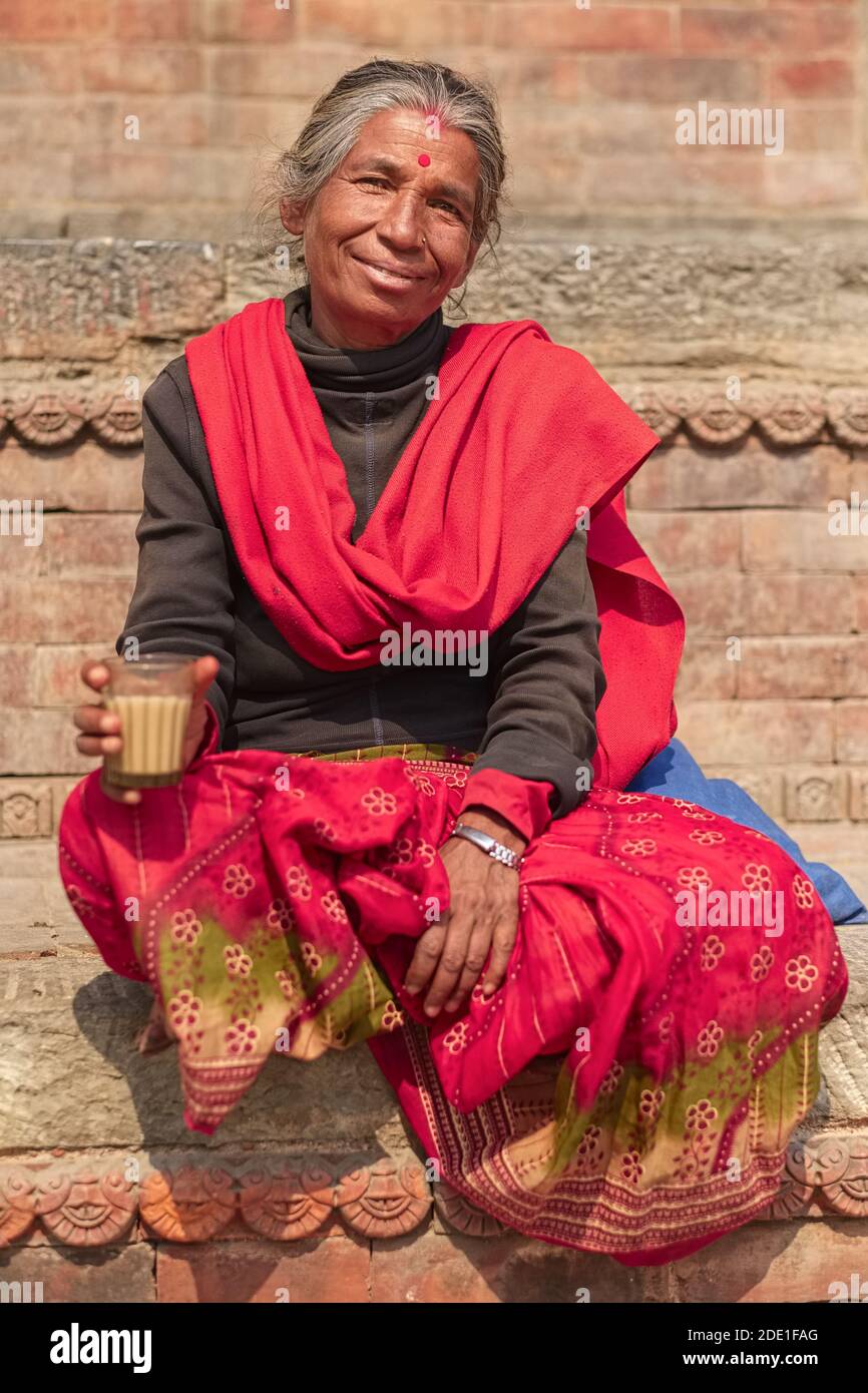 A Nepalese woman in traditonal dress, in Kathmandu, Nepal, enjoying a ...