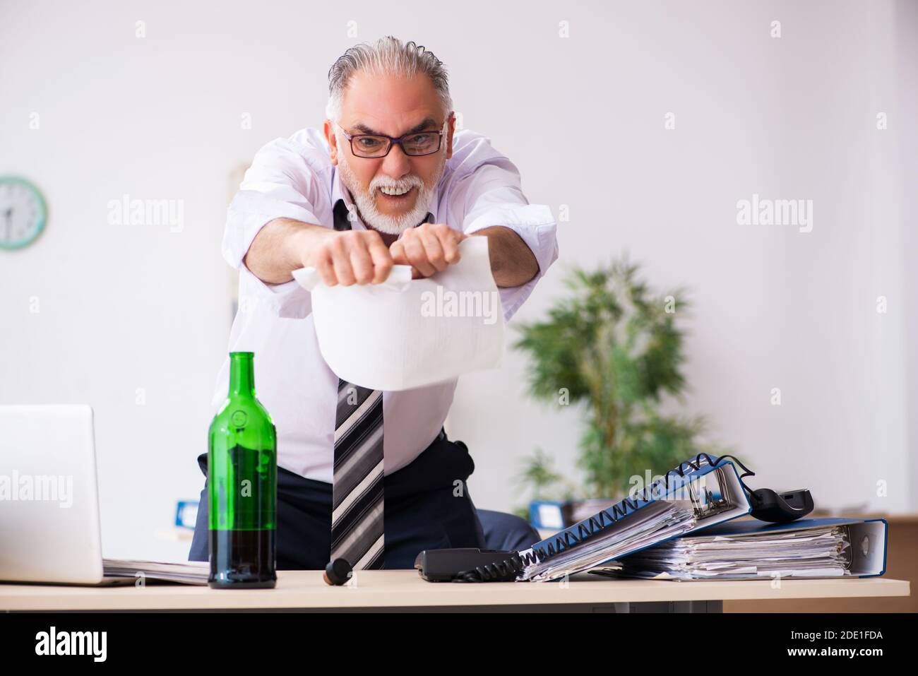 Old businessman drinking alcohol in the office Stock Photo - Alamy