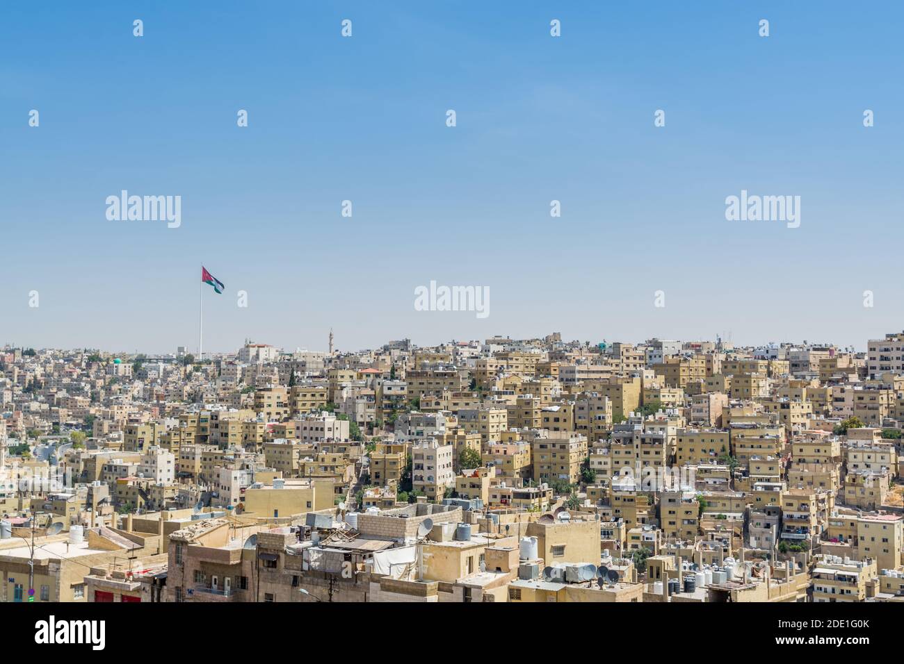 Cityscape of Amman with numerous buildings and Jordanian national flag ...