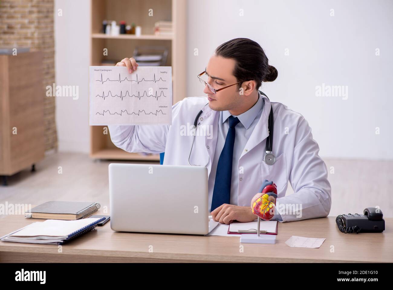 Young doctor cardiologist looking electrocardiogram Stock Photo - Alamy