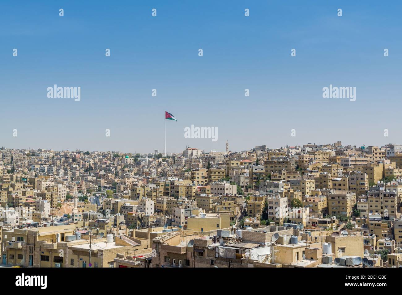 Cityscape of Amman with numerous buildings and Jordanian national flag ...