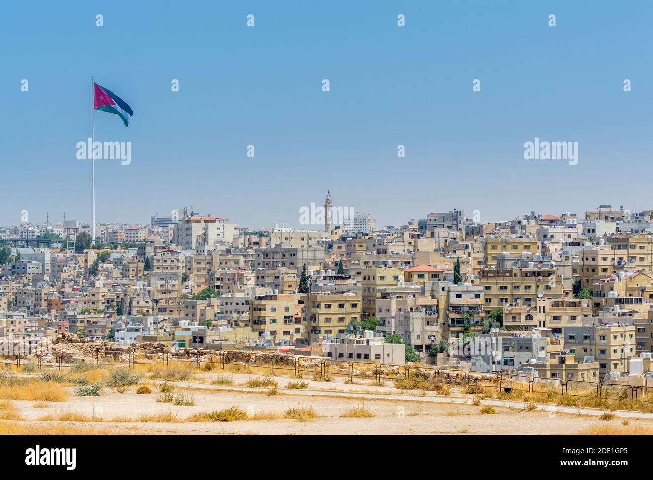 Cityscape of Amman with numerous buildings and Jordanian national flag ...