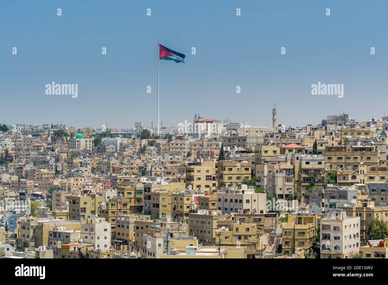 Cityscape of Amman with numerous buildings and Jordanian national flag ...