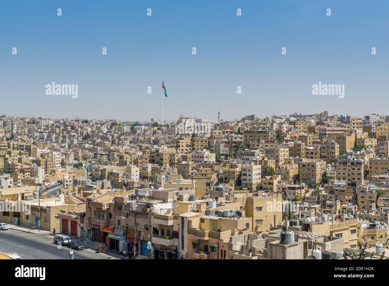 Cityscape of Amman with numerous buildings and Jordanian national flag ...
