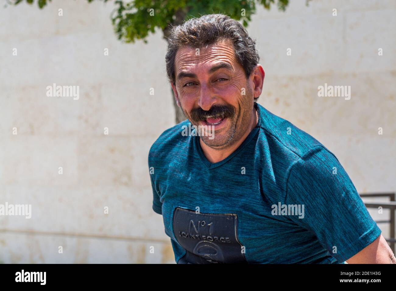 A local Jordanian guide with big smiling face at the Amman Citadel, a ...