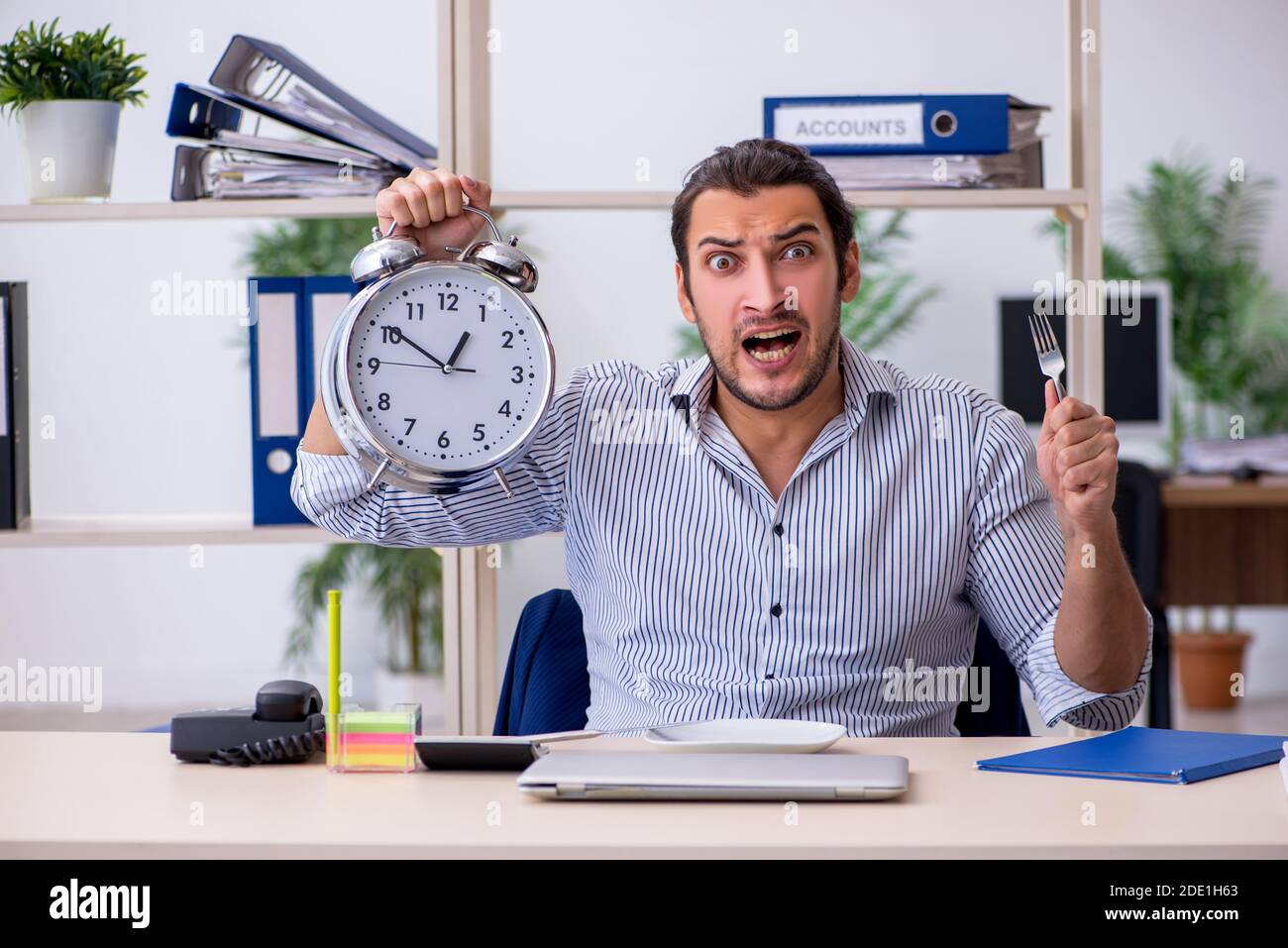 Hungry employee waiting for food in time management concept Stock Photo ...