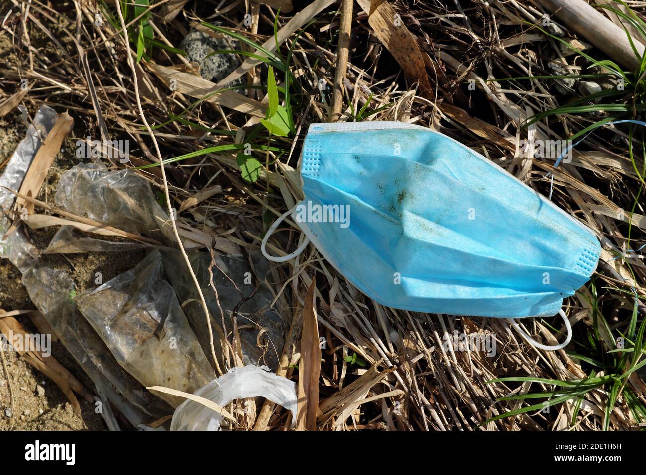 Littered and floating used surgical face mask garbage on a river. Water ...
