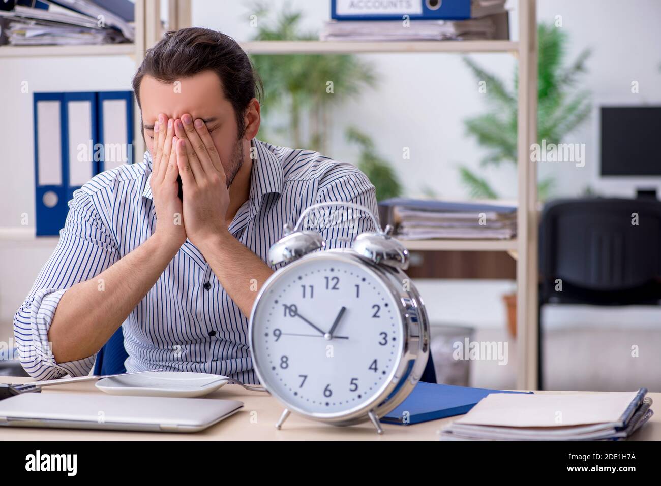 Hungry employee waiting for food in time management concept Stock Photo ...