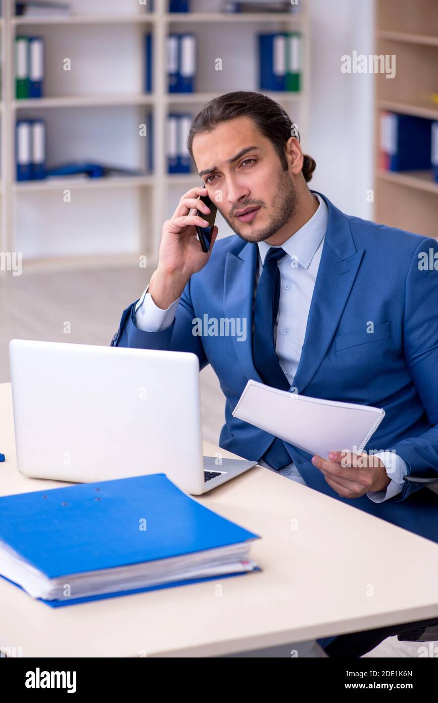 Young employee working at workplace Stock Photo - Alamy