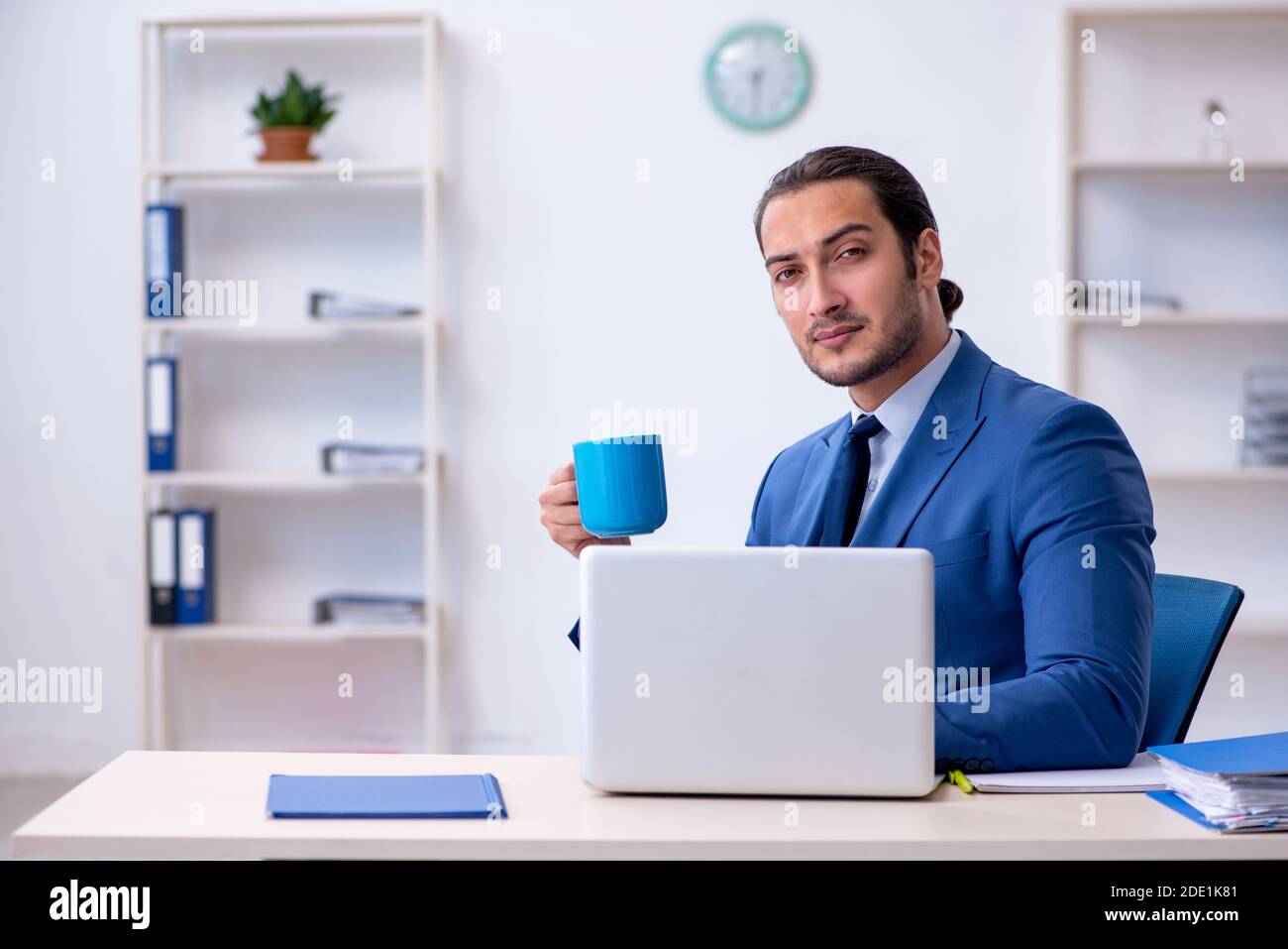 Young employee drinking coffee during break Stock Photo - Alamy
