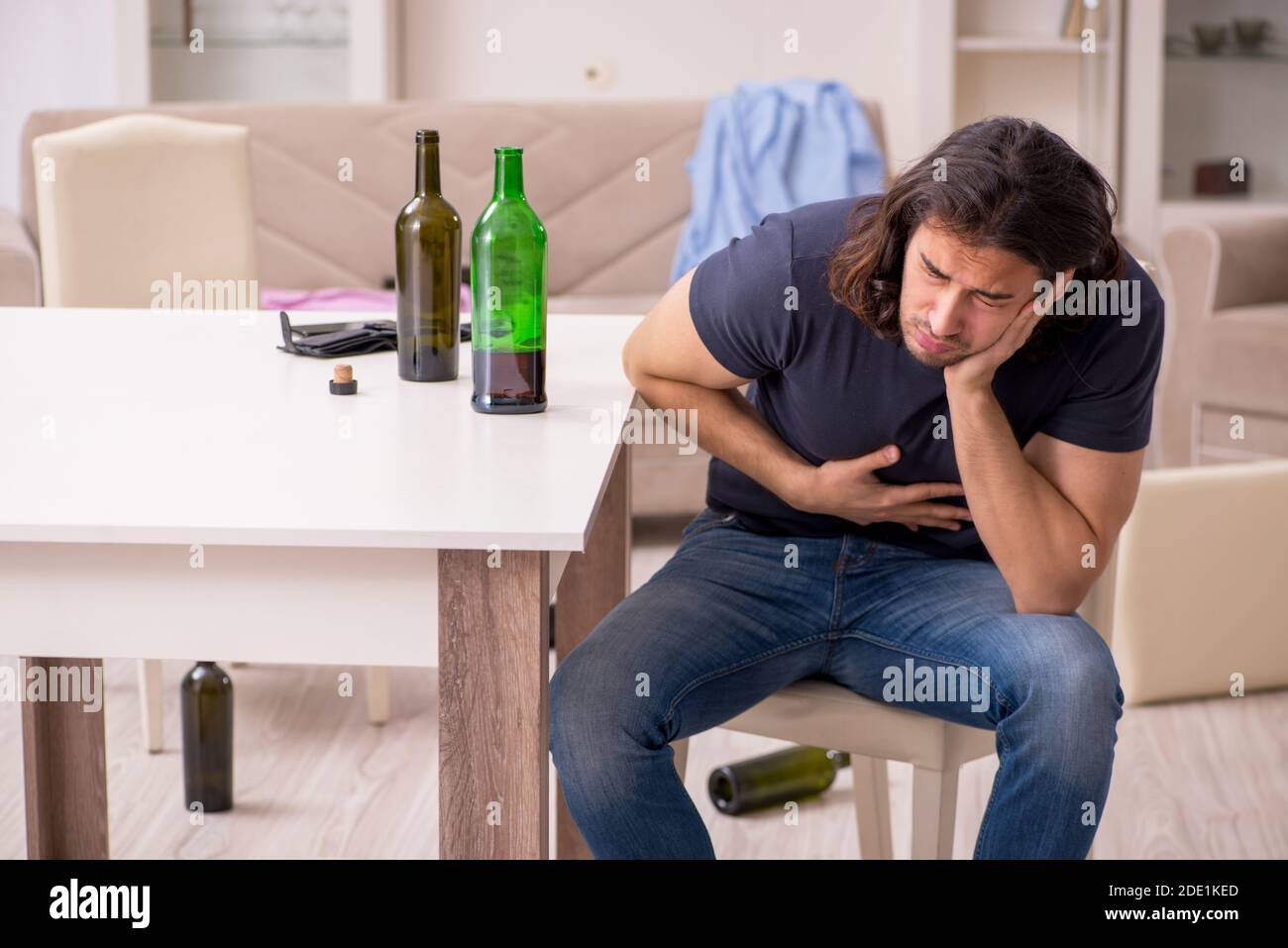 Young addicted man suffering from stomachache at home Stock Photo - Alamy