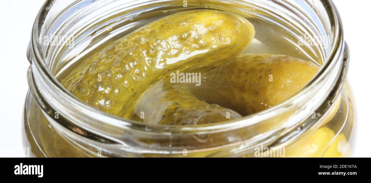 several pickled green pickles in a glass Stock Photo - Alamy