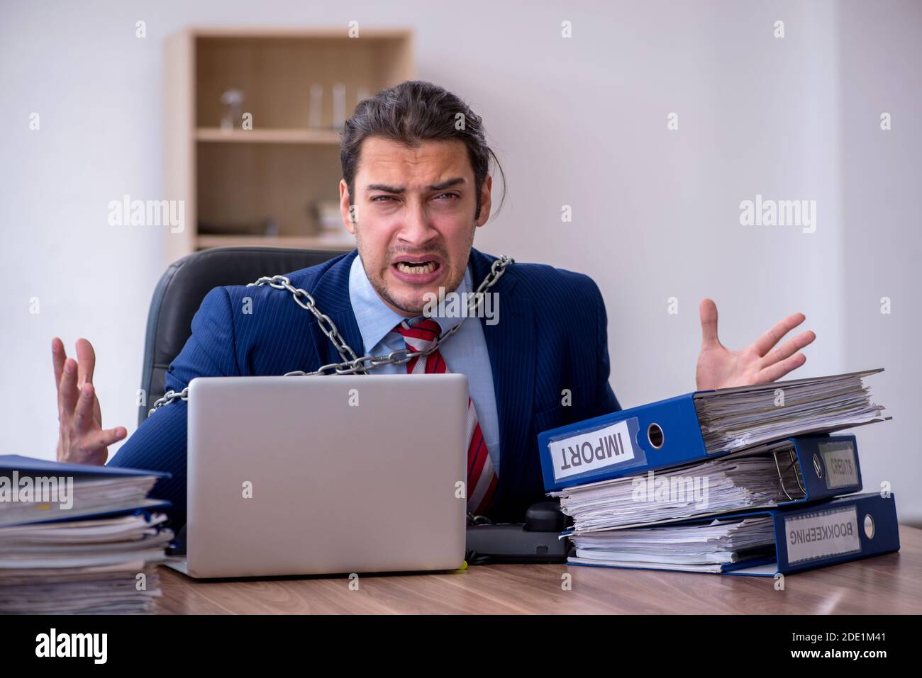 Chained employee unhappy with excessive work in the office Stock Photo ...